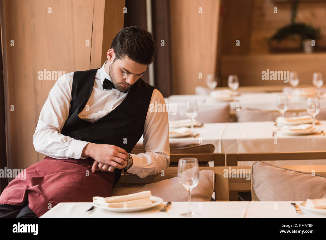 Waiter looking at watch Stock Photo - Alamy