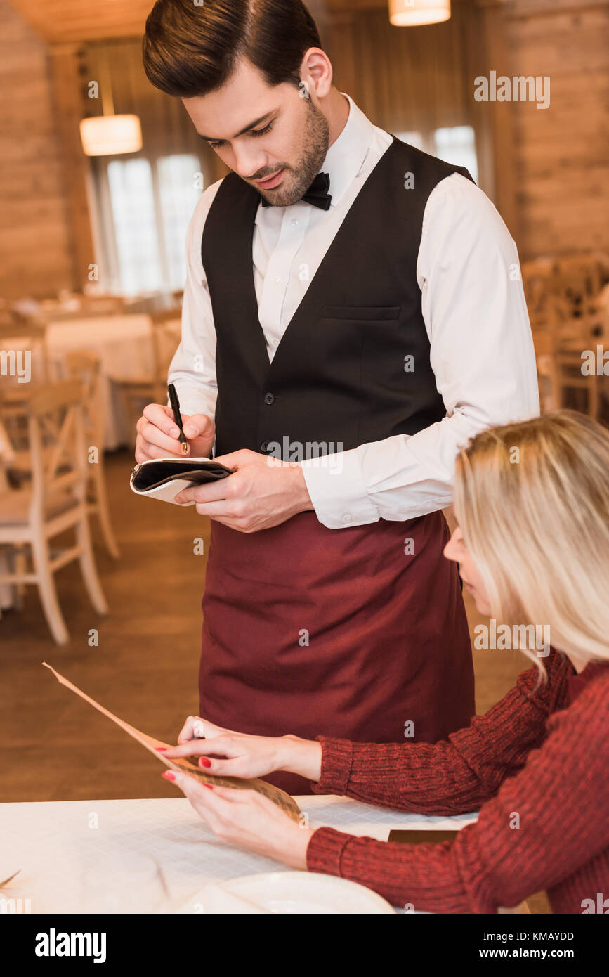 Waiter writing down the order of customer Stock Photo - Alamy