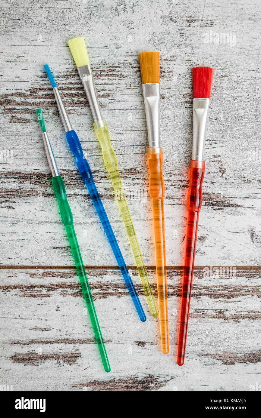 Colorful plastic brushes on white wooden background Stock Photo - Alamy