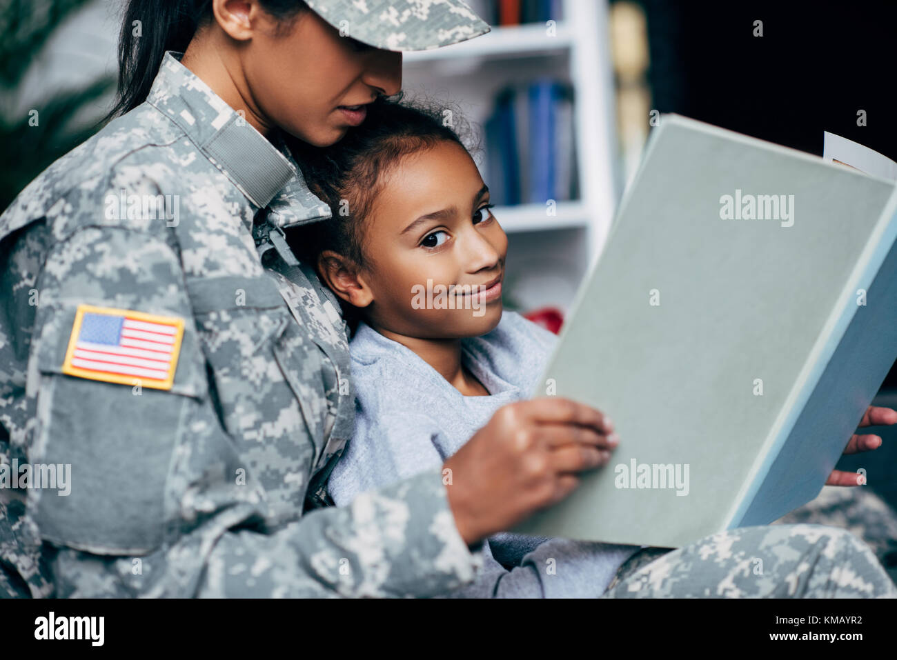 daughter and female soldier reading book Stock Photo - Alamy