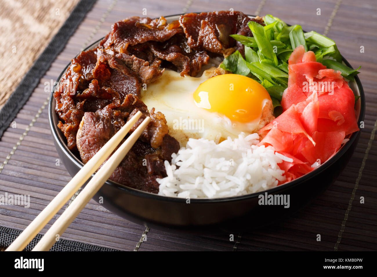 Japanese gyudon beef with rice, egg, ginger and onion close-up in a ...