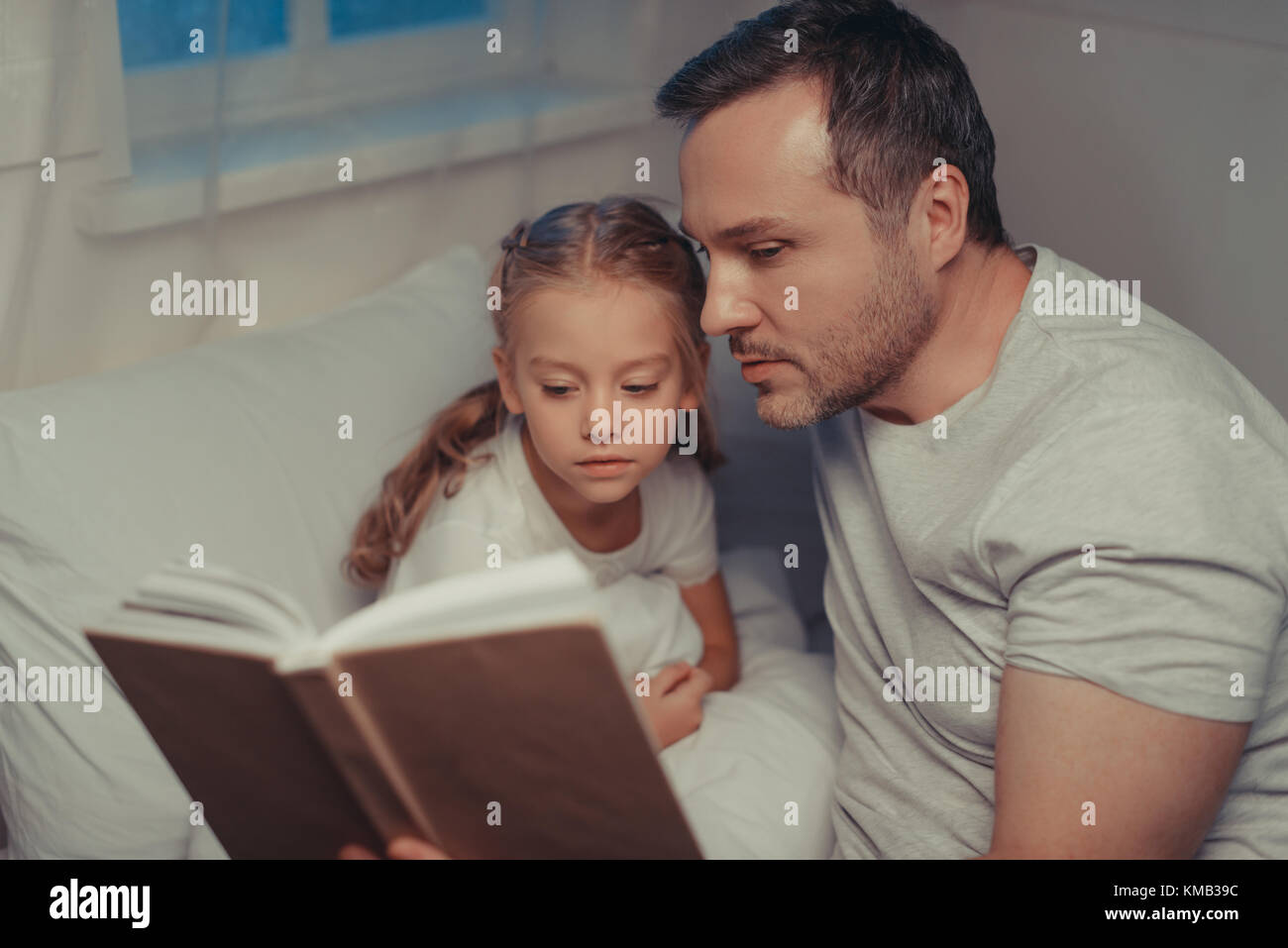 family reading book at bedtime Stock Photo - Alamy