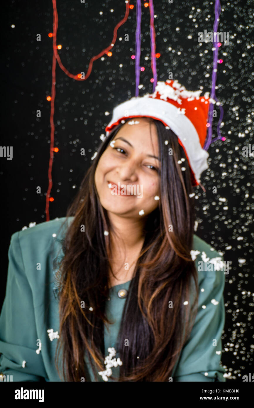 Smiling girl wearing a Christmas hat in snow Stock Photo - Alamy