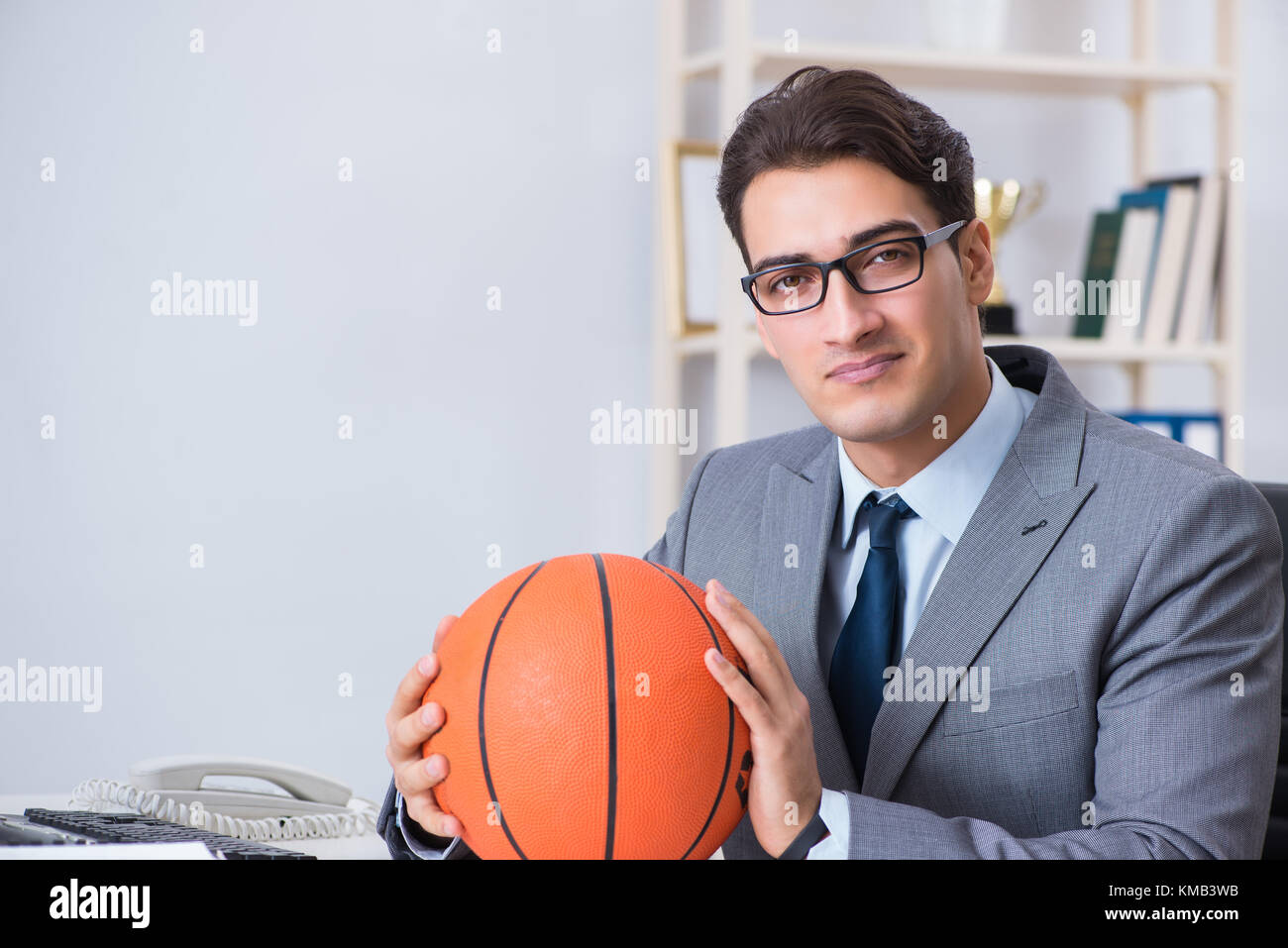 Young businessman playing basketball in office during break Stock Photo ...