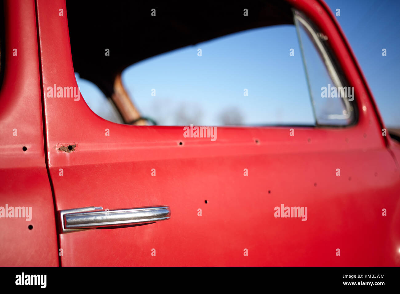 Side window and door handle of an old vintage red car with missing ...