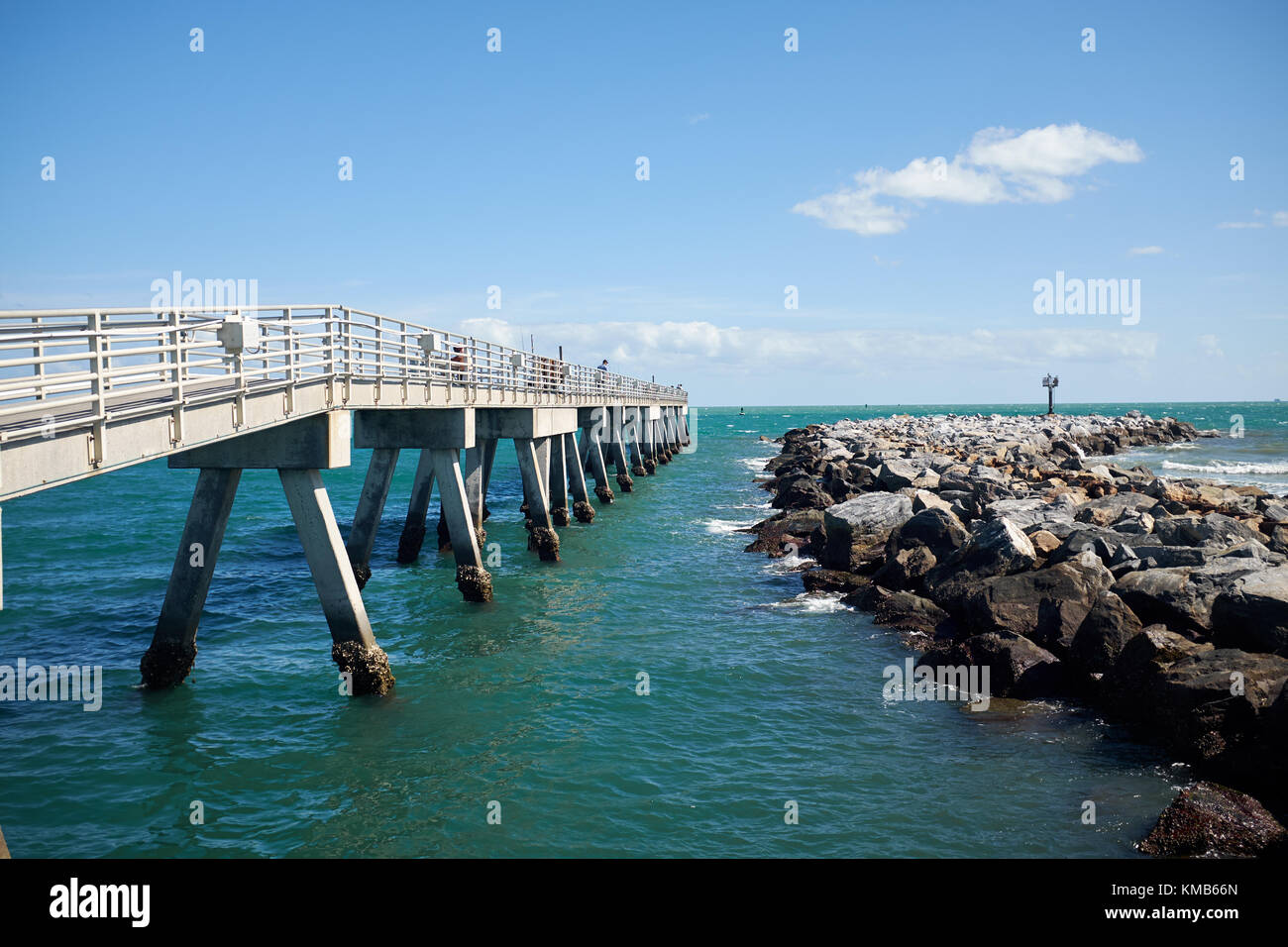 Natural rock breakwater and pier in Florida, USA in a calm blue ocean ...