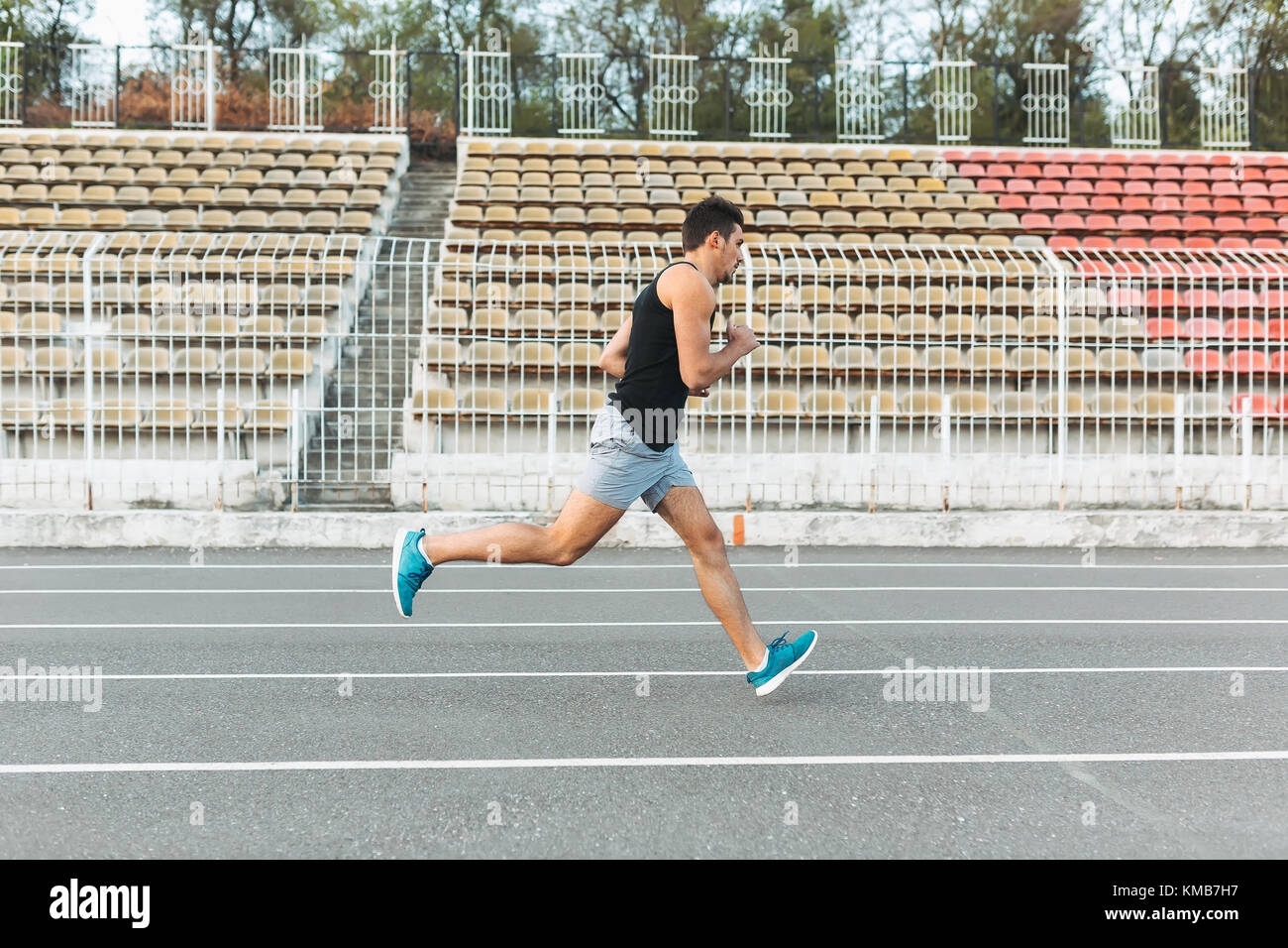 Young athletic man running on the stadium in the morning Stock Photo ...