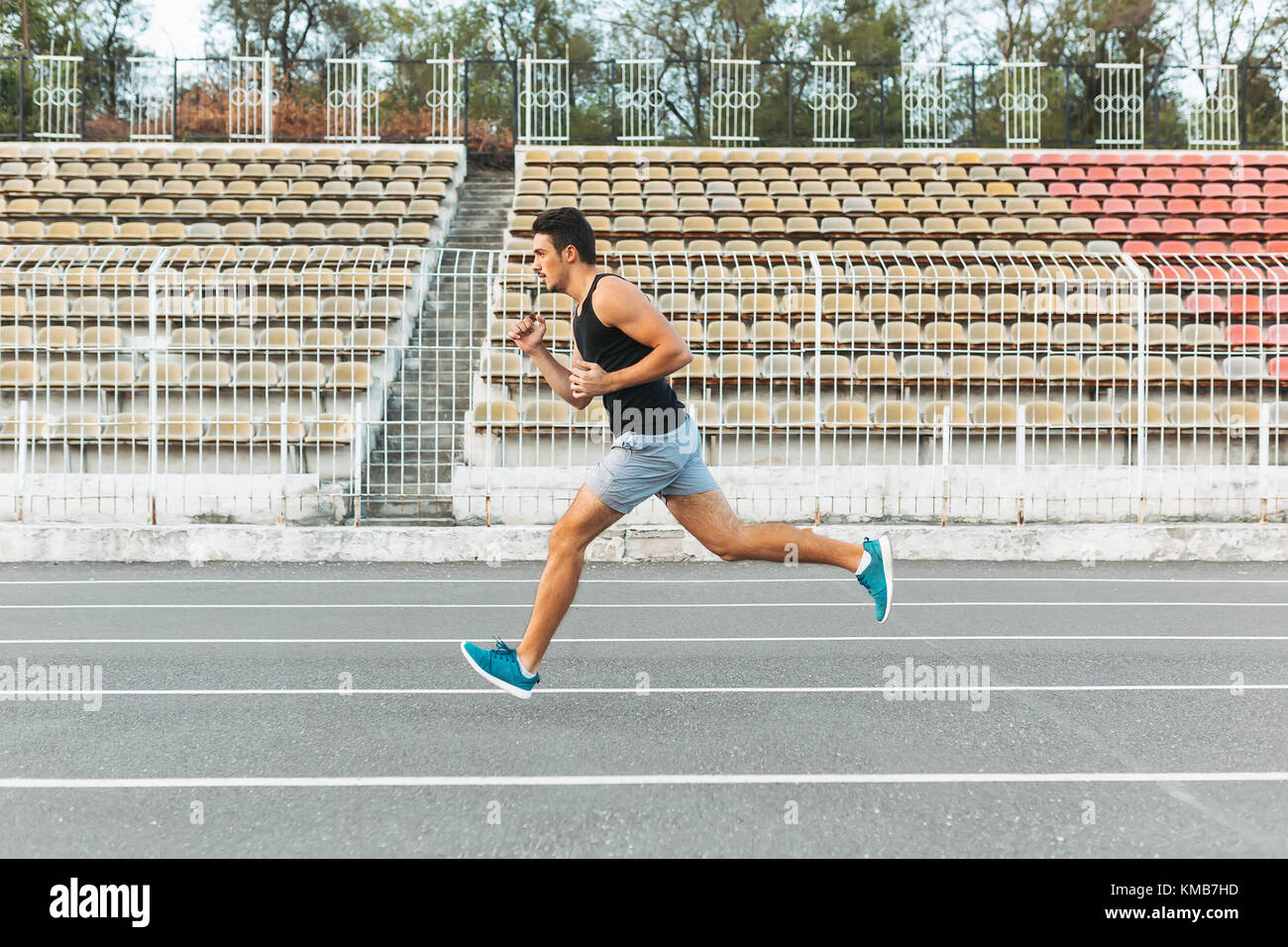 Young athletic man running on the stadium in the morning Stock Photo ...