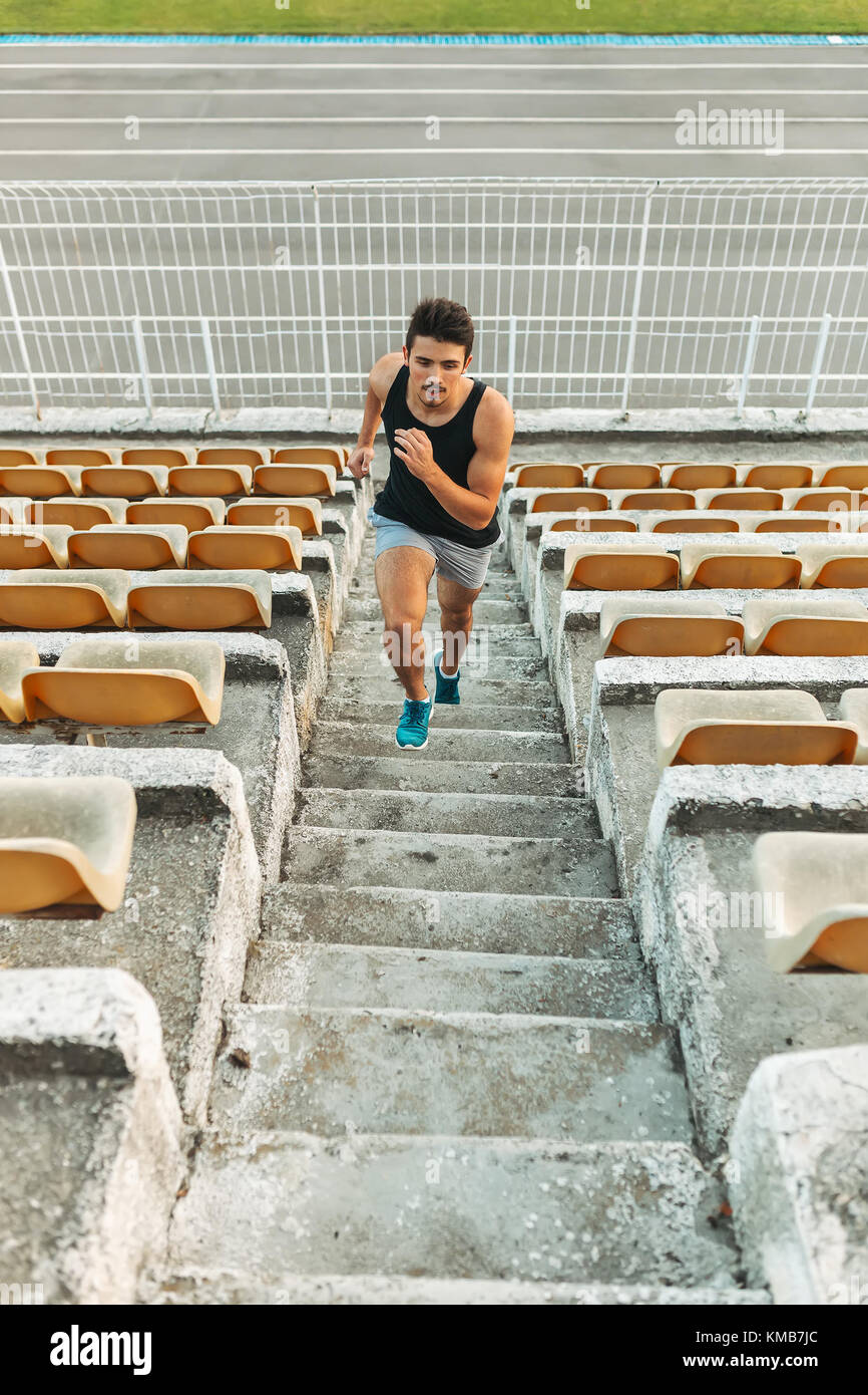 Image of young athletic man running by ladder at the stadium out Stock ...