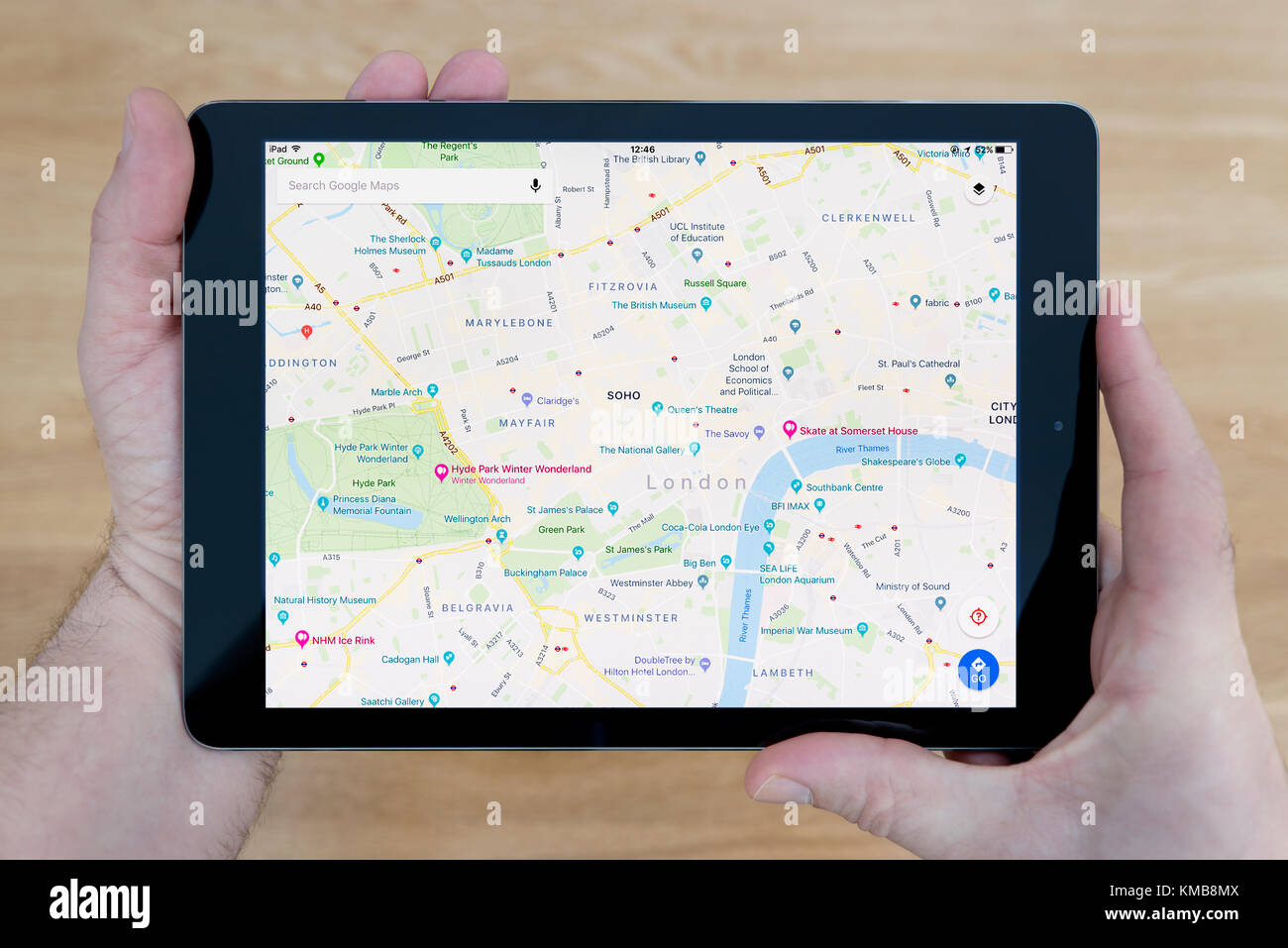 A man looks at the Google Maps website on his iPad tablet device, shot ...
