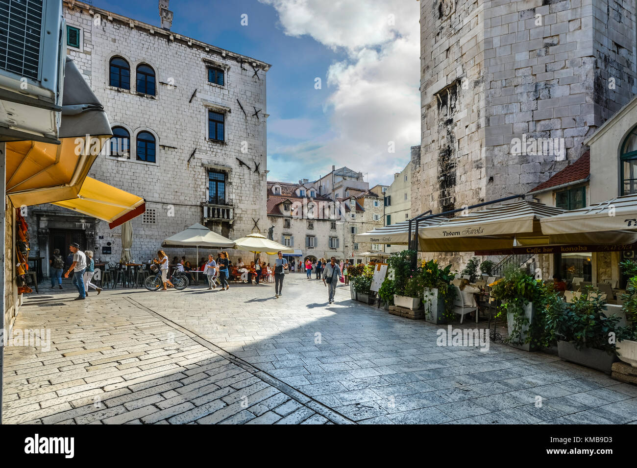 Tourists and locals enjoy an outdoor, sidewalk cafe in the historic ...