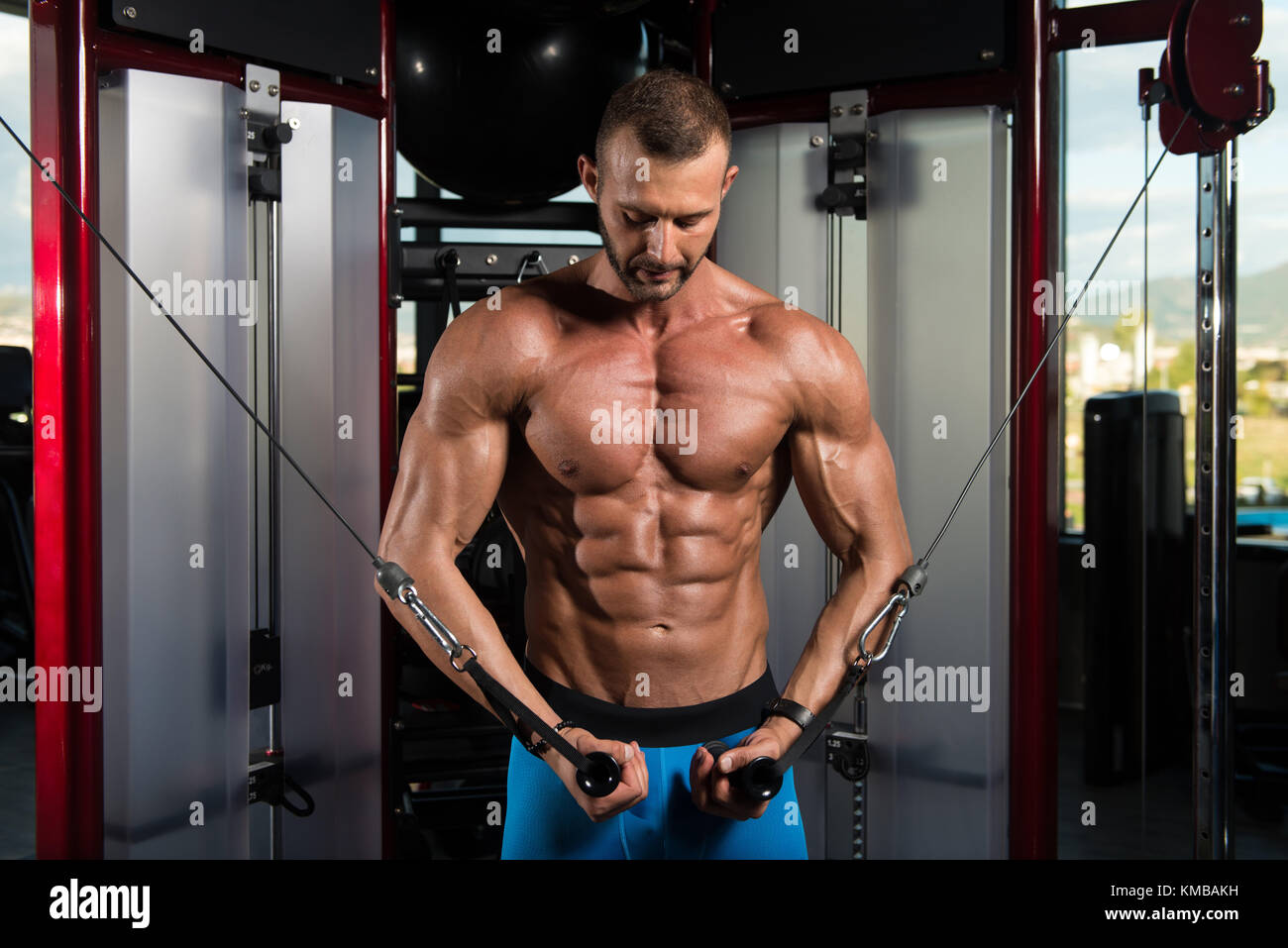 Muscular Man Doing Heavy Weight Exercise For Chest On Machine With ...