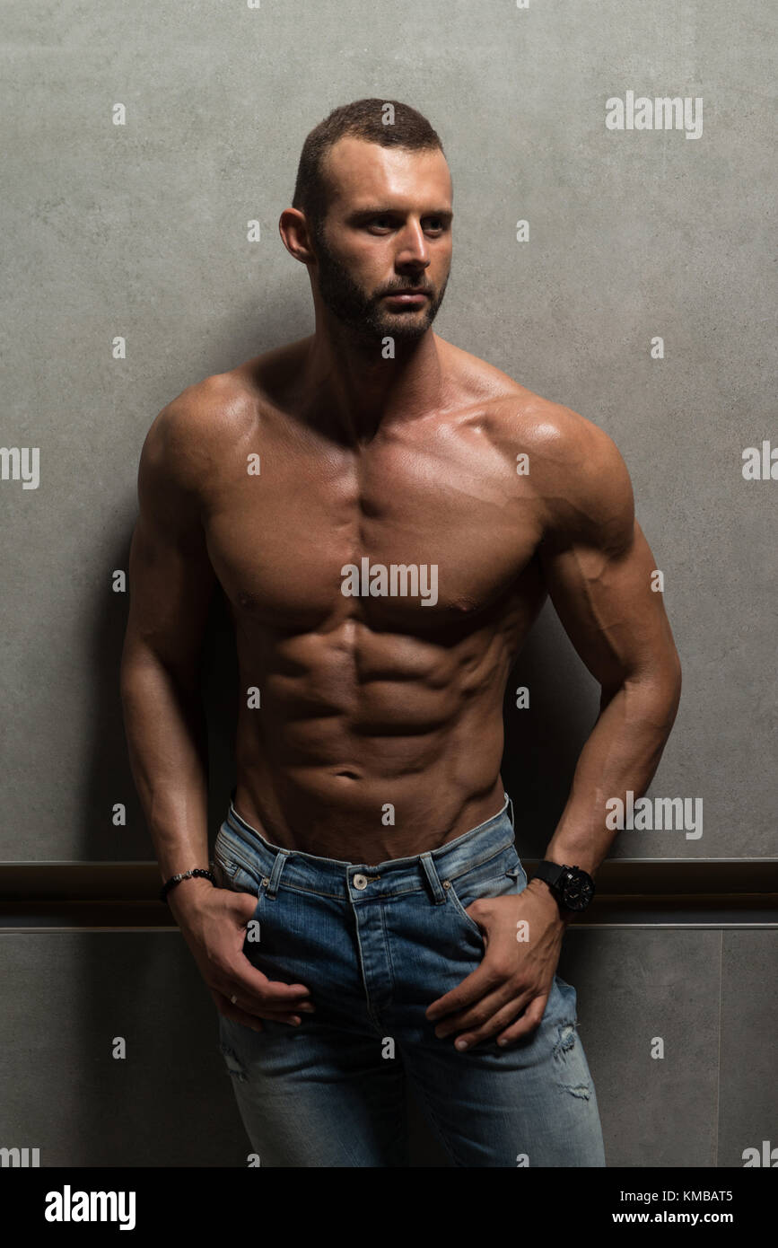Healthy Young Man Standing Strong Standing Against a Wall and Flexing ...