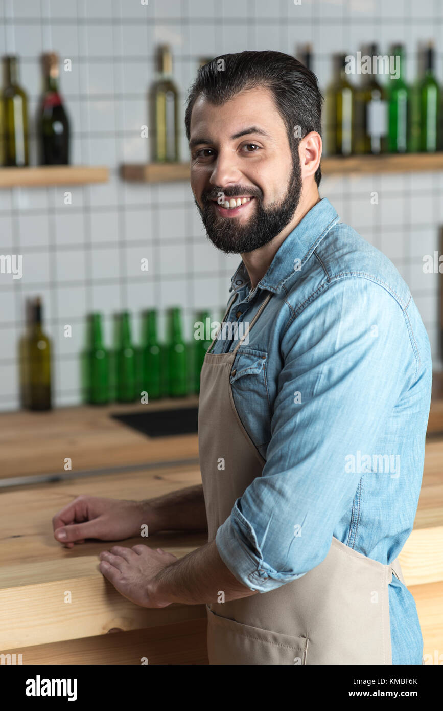 Handsome young man standing in a cafe and smiling Stock Photo - Alamy