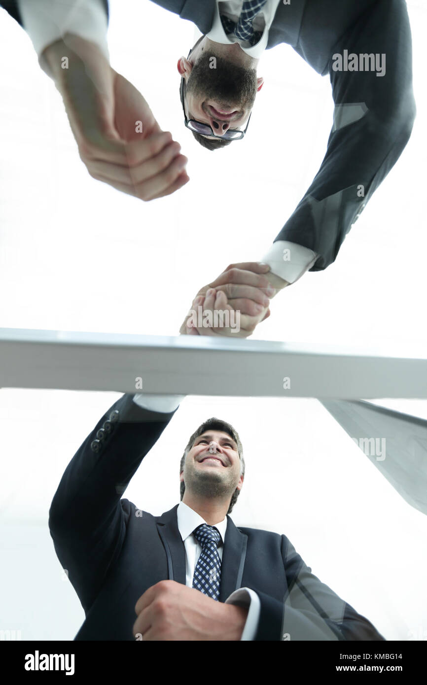 View from below. From behind the glass. Handshake of business partners ...