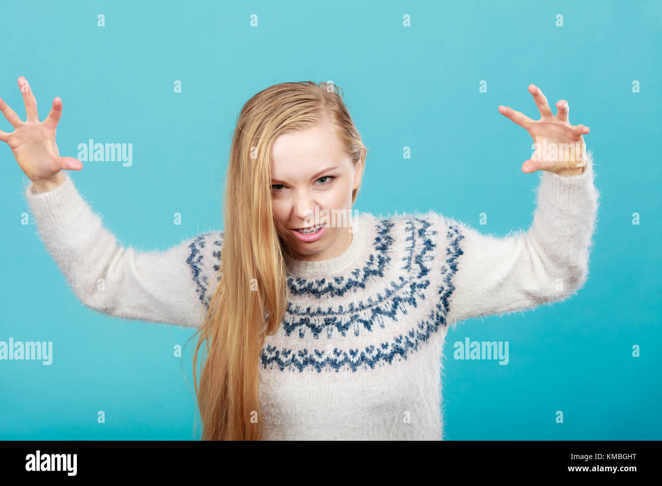 Fooling around concept. Young blonde teenage woman making scary faces ...