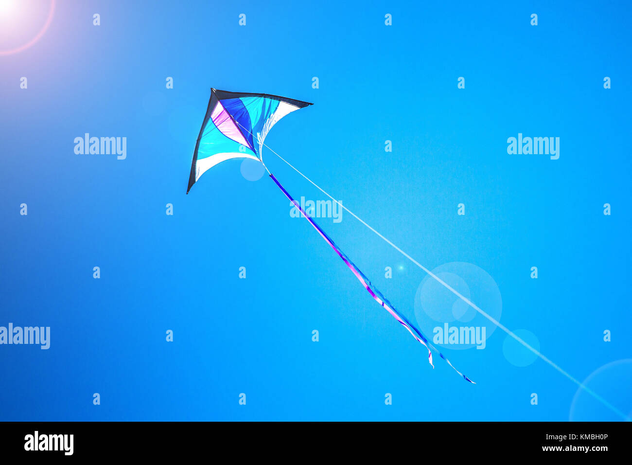 Triangle kite flying on a sunny day blue sky Stock Photo - Alamy