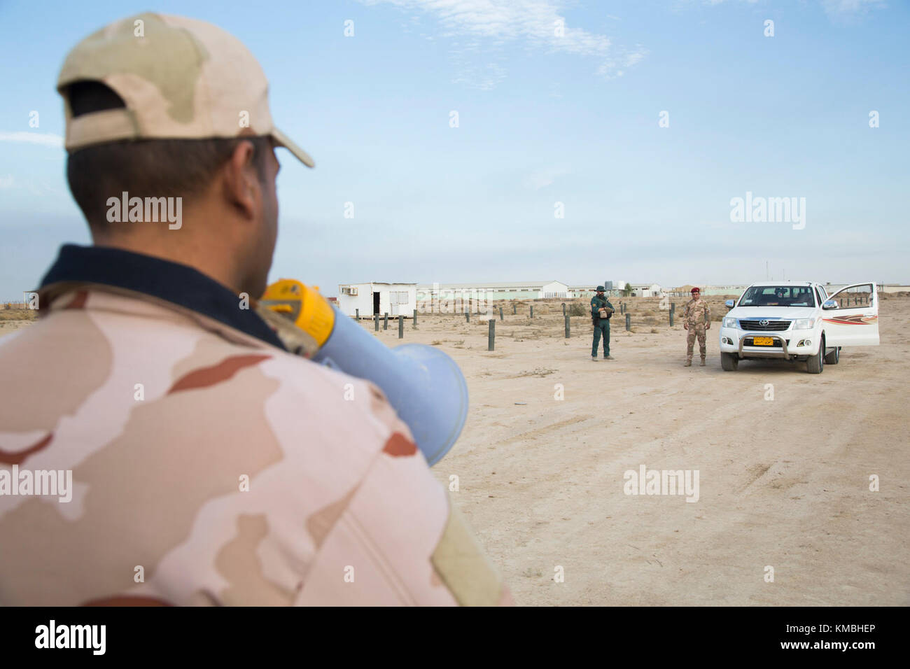 An Iraqi soldier delivers instructions to a fellow soldier while a ...