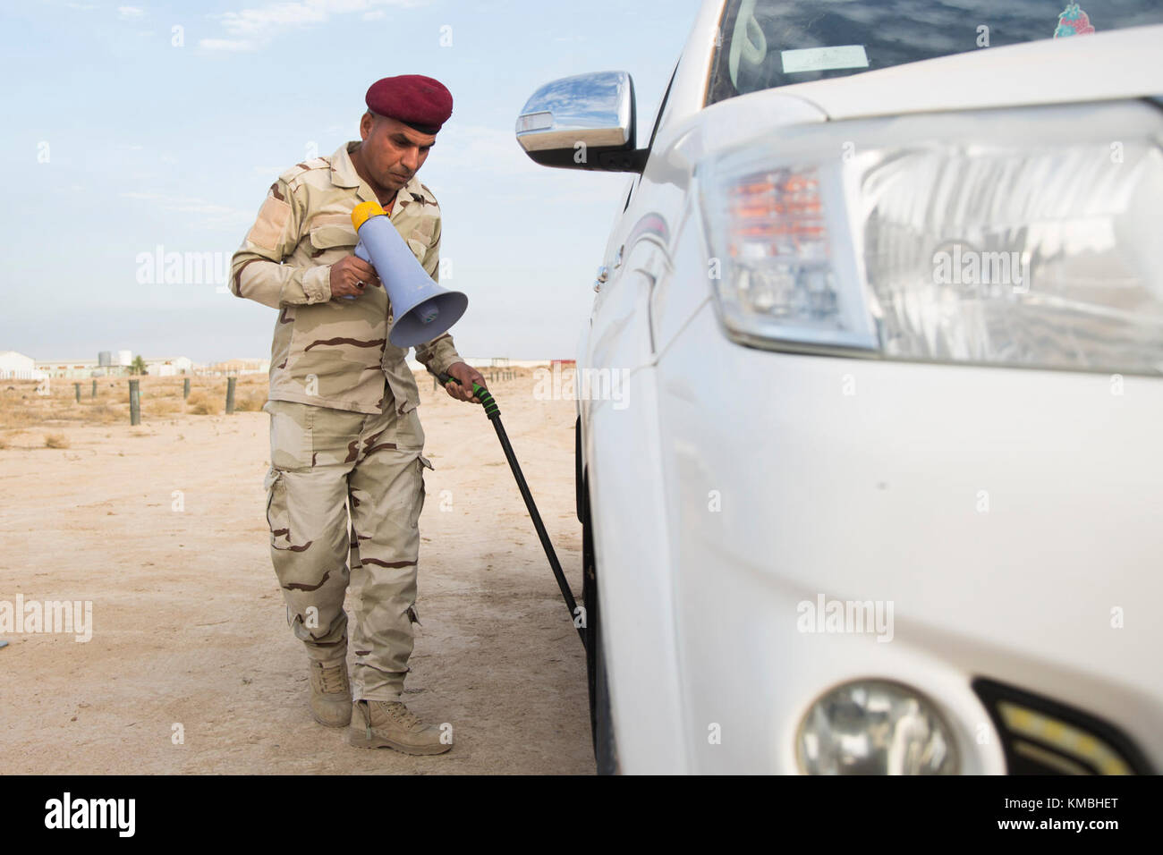 An Iraqi soldier inspects a vehicle for improvised explosive devices ...