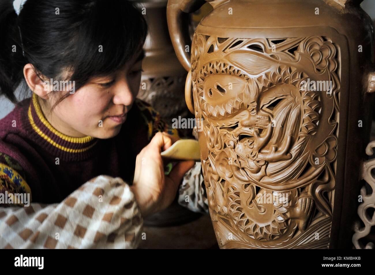 Traditional Longshan Chinese black pottery. Artist finishing vase ...