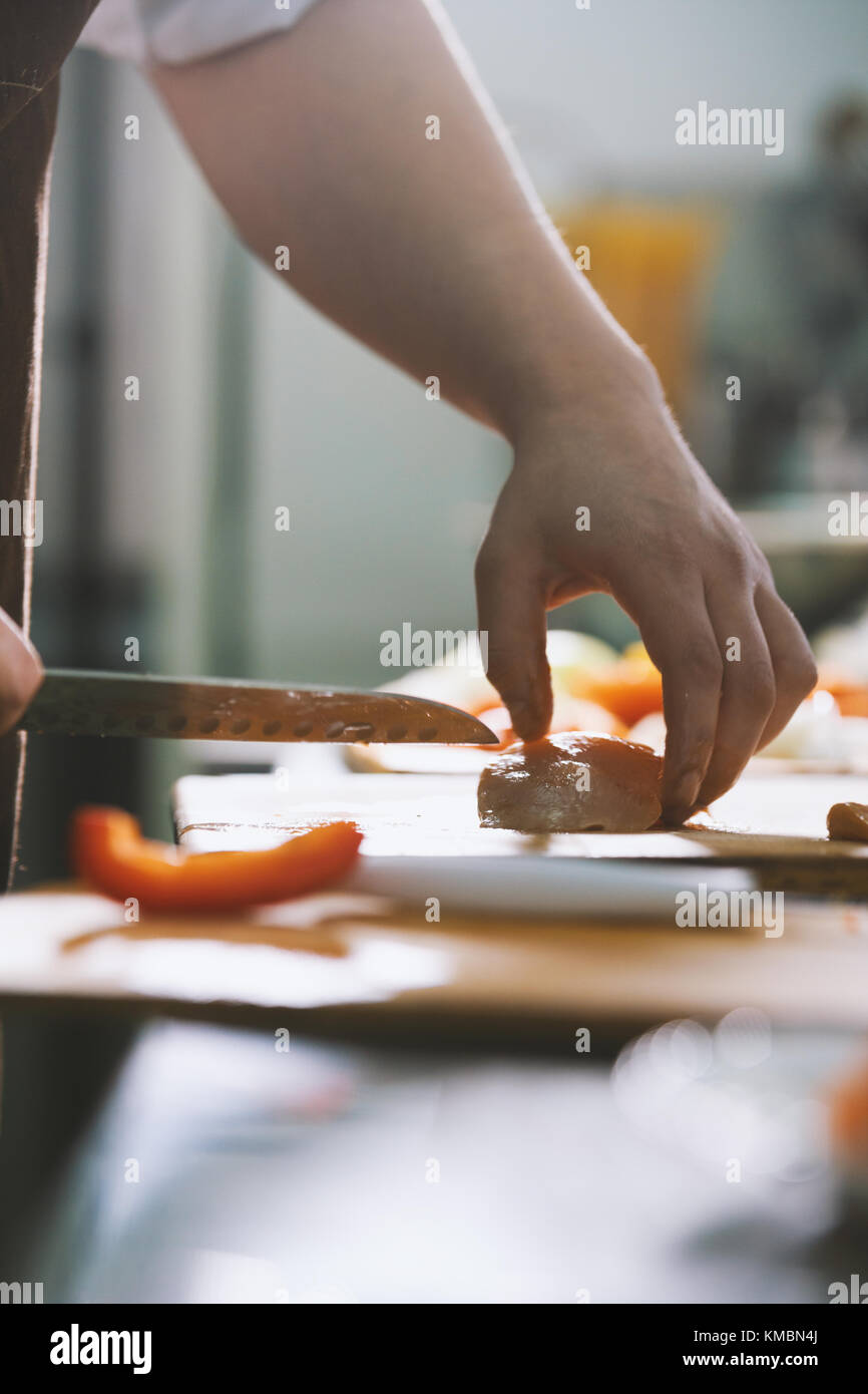 chef cuts the meat in commercial kitchen Stock Photo - Alamy