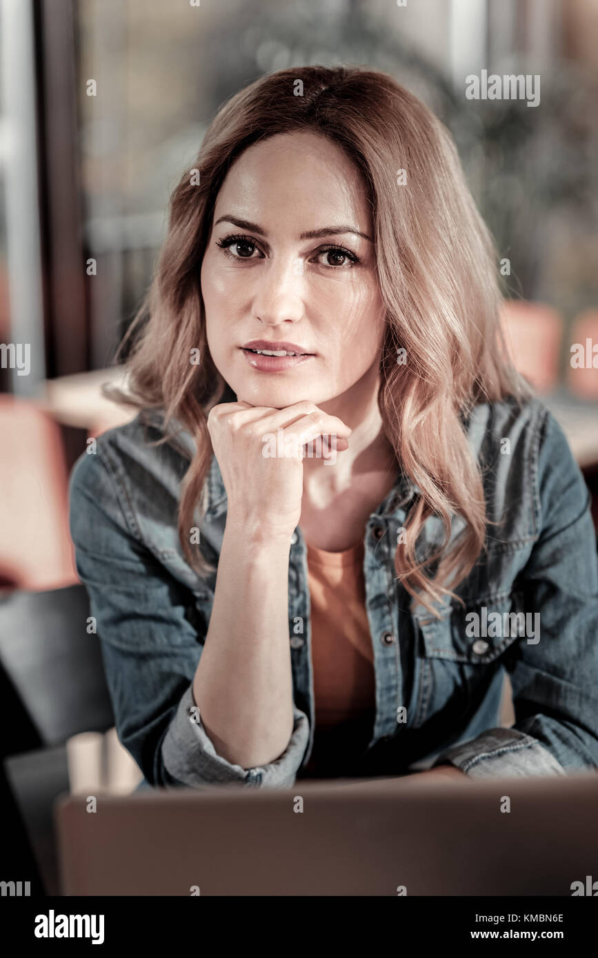 Calm beautiful young woman sitting calmly while waiting for her friend ...
