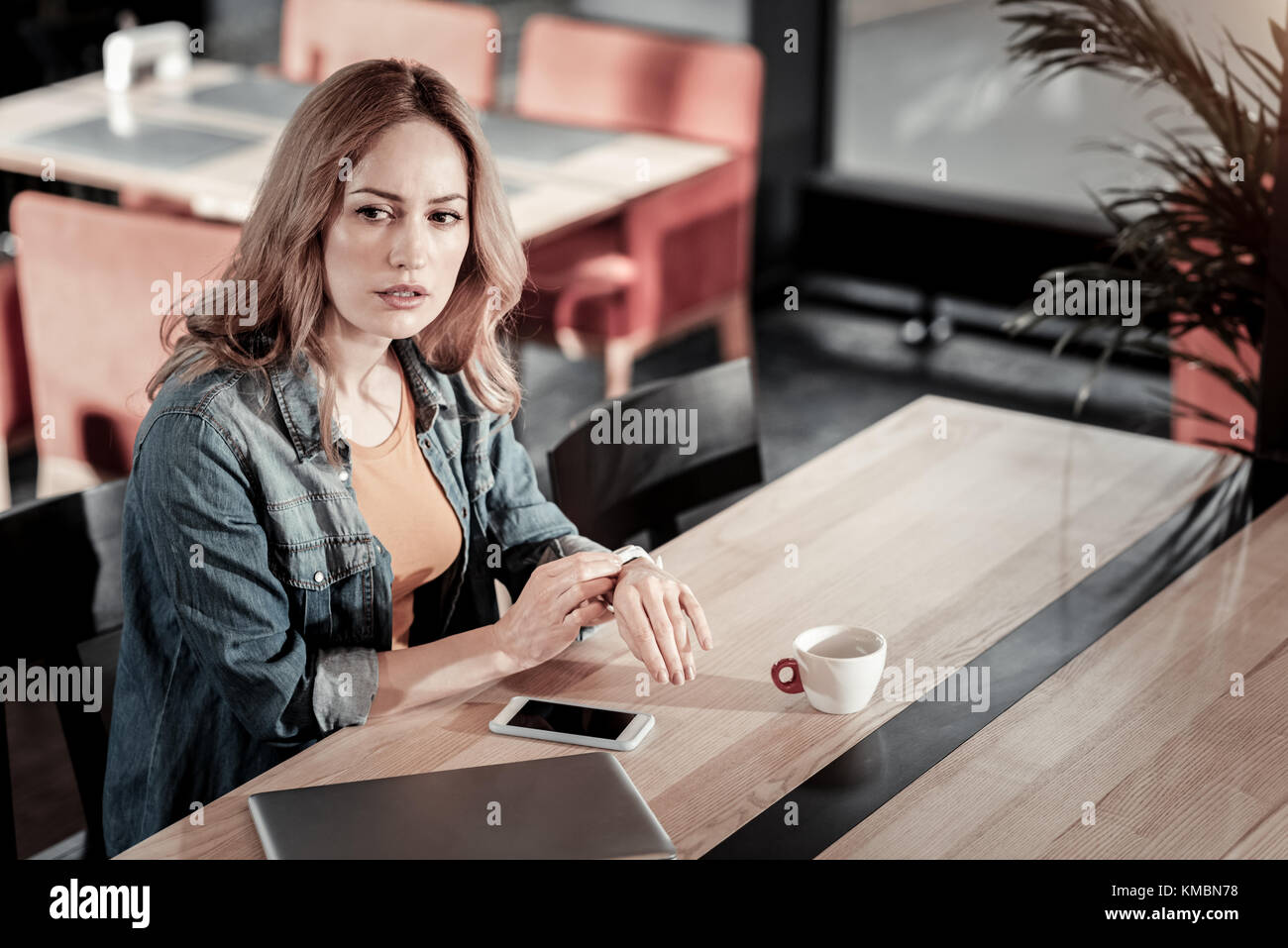 Serious attentive woman sitting thoughtfully in a cafe Stock Photo - Alamy