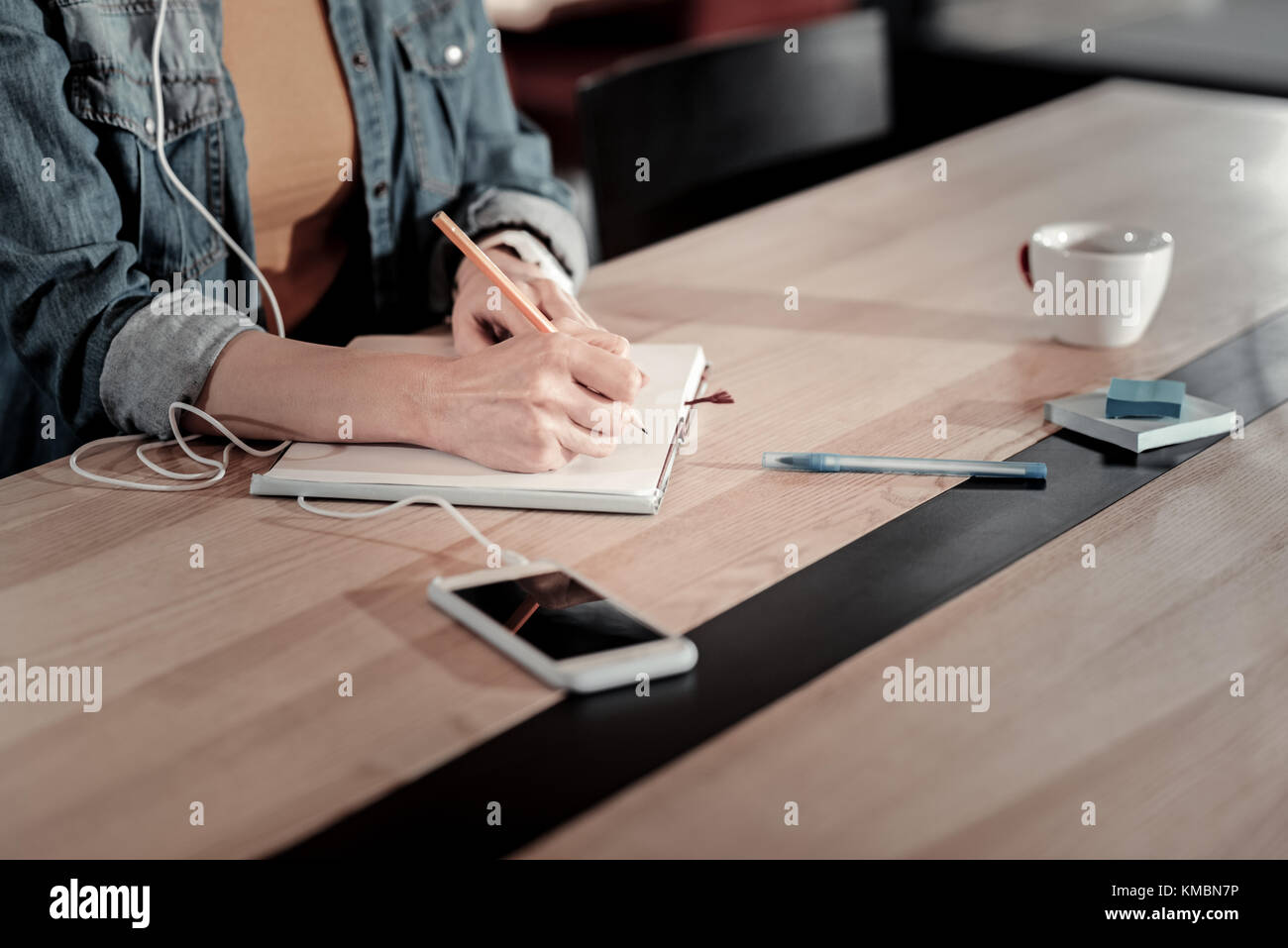 Attentive clever student making notes while drinking coffee Stock Photo ...