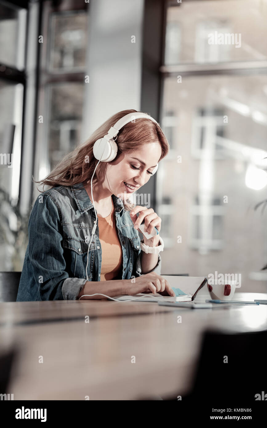 Positive young woman looking at her notes and smiling Stock Photo - Alamy