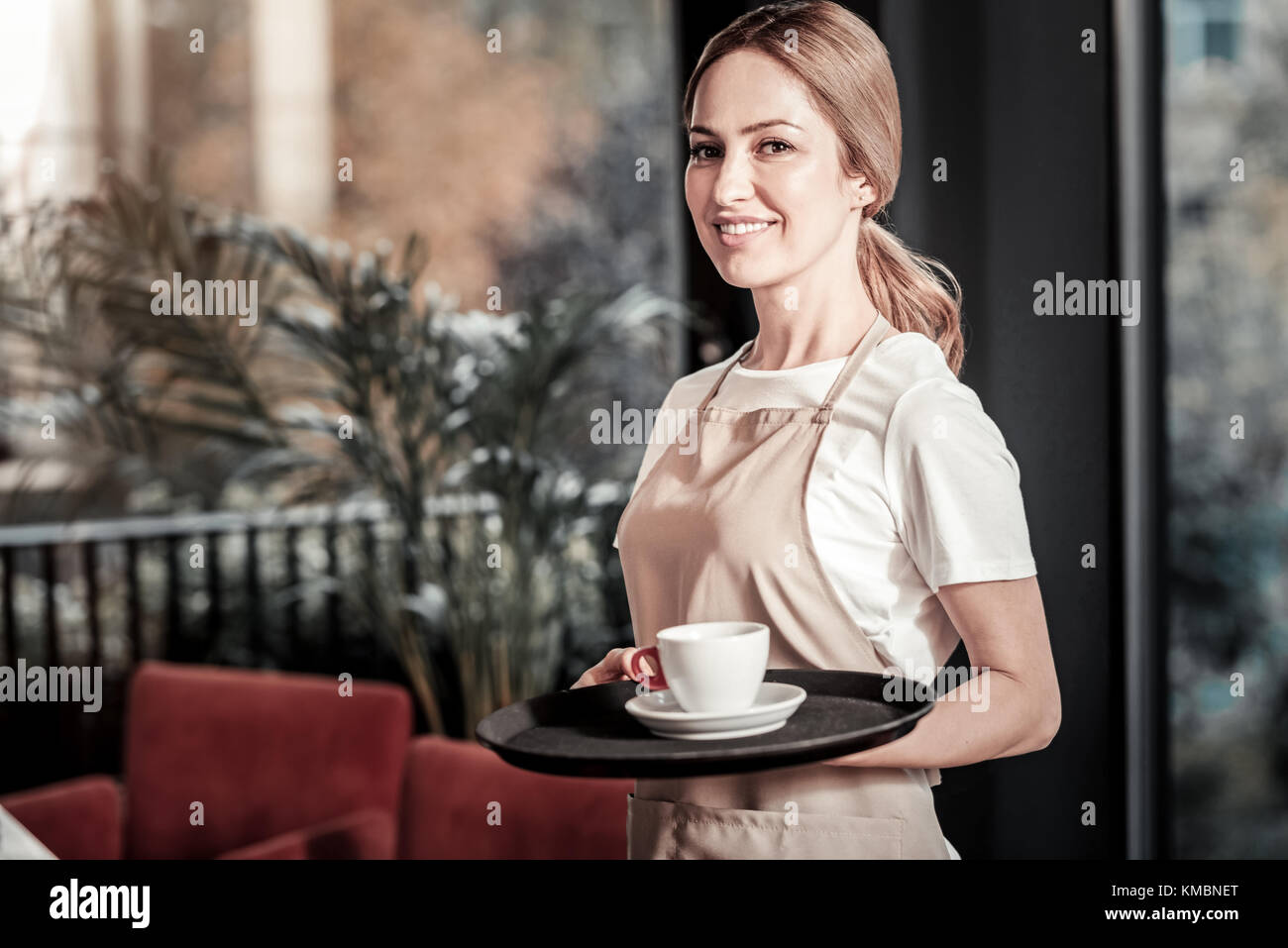 Beautiful waitress standing and holding a tray with a cup of coffee ...