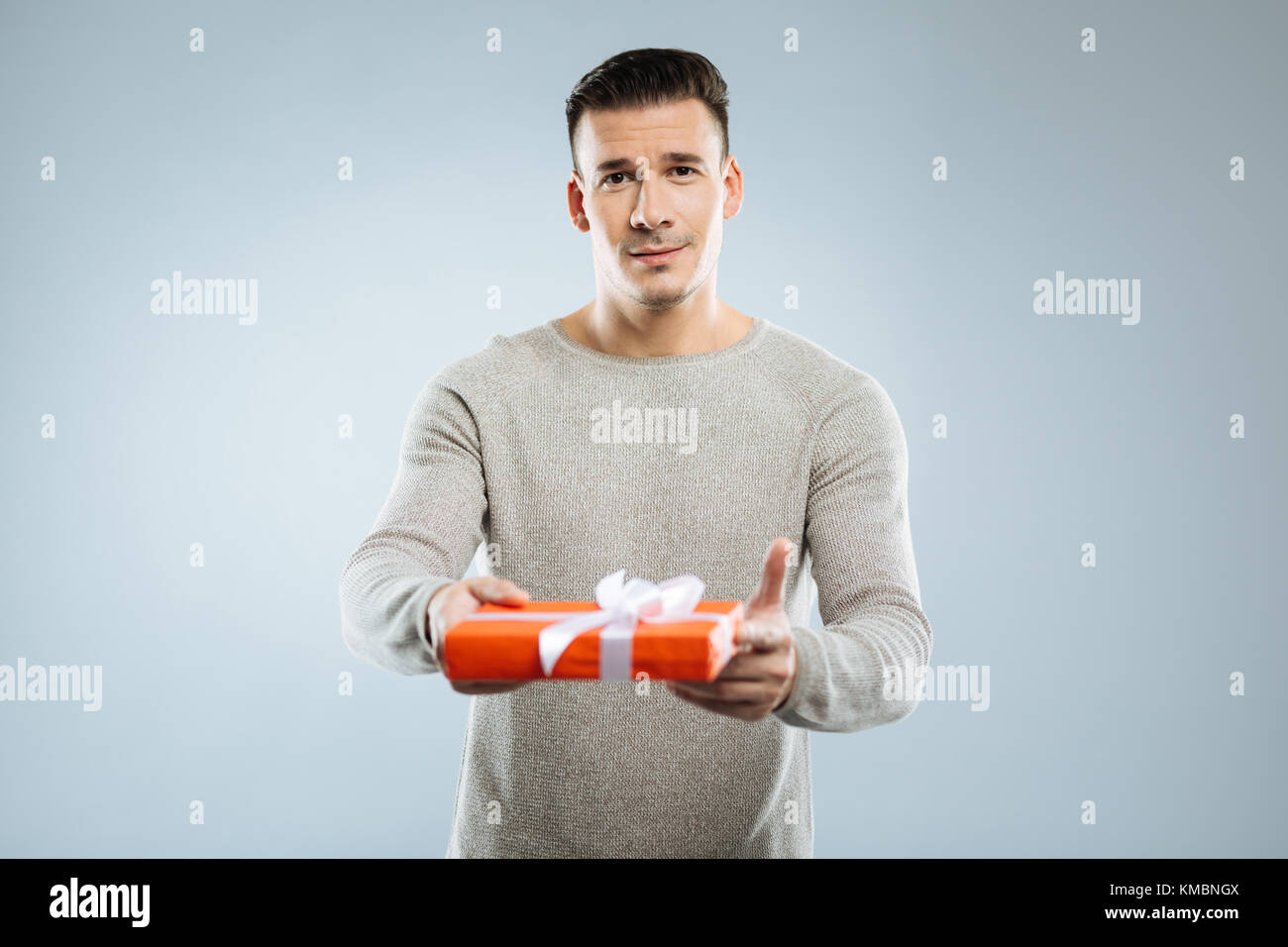 Handsome male person presenting gift Stock Photo - Alamy