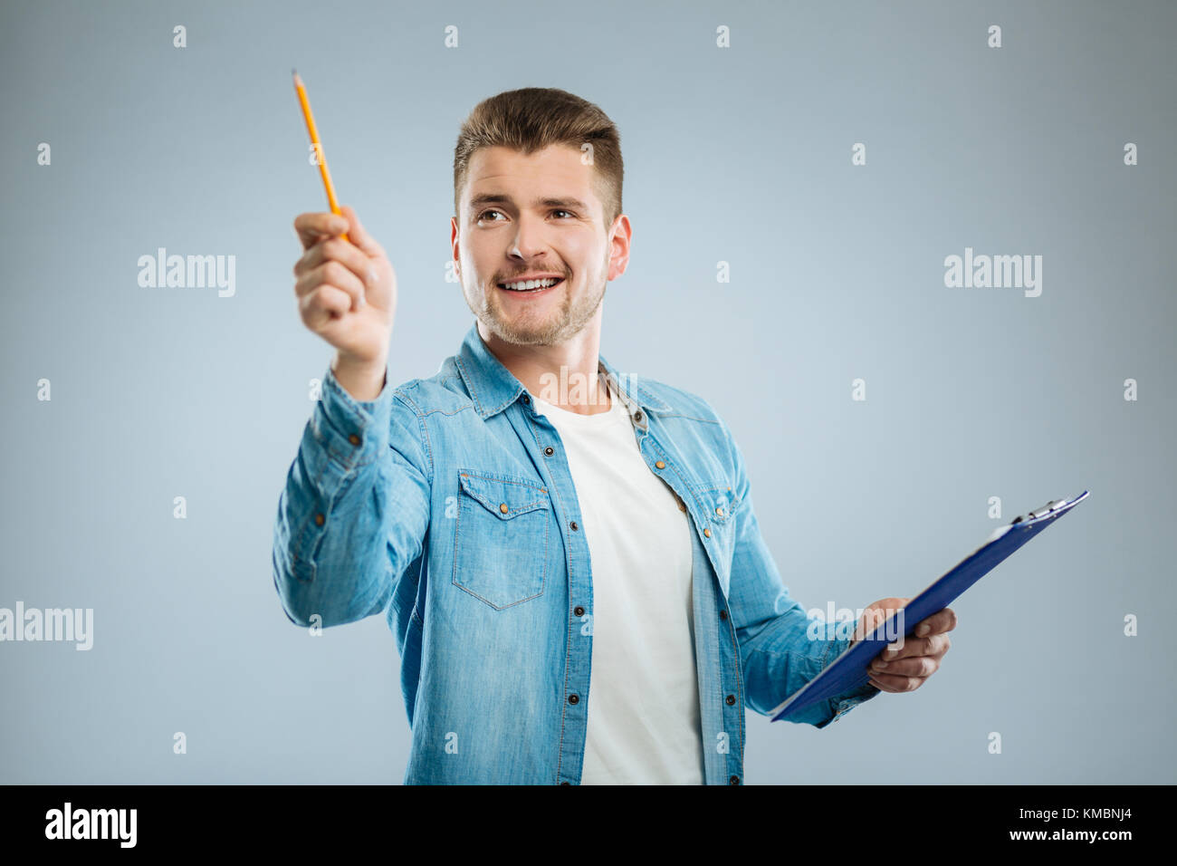 Attentive brunette looking at his pencil Stock Photo - Alamy