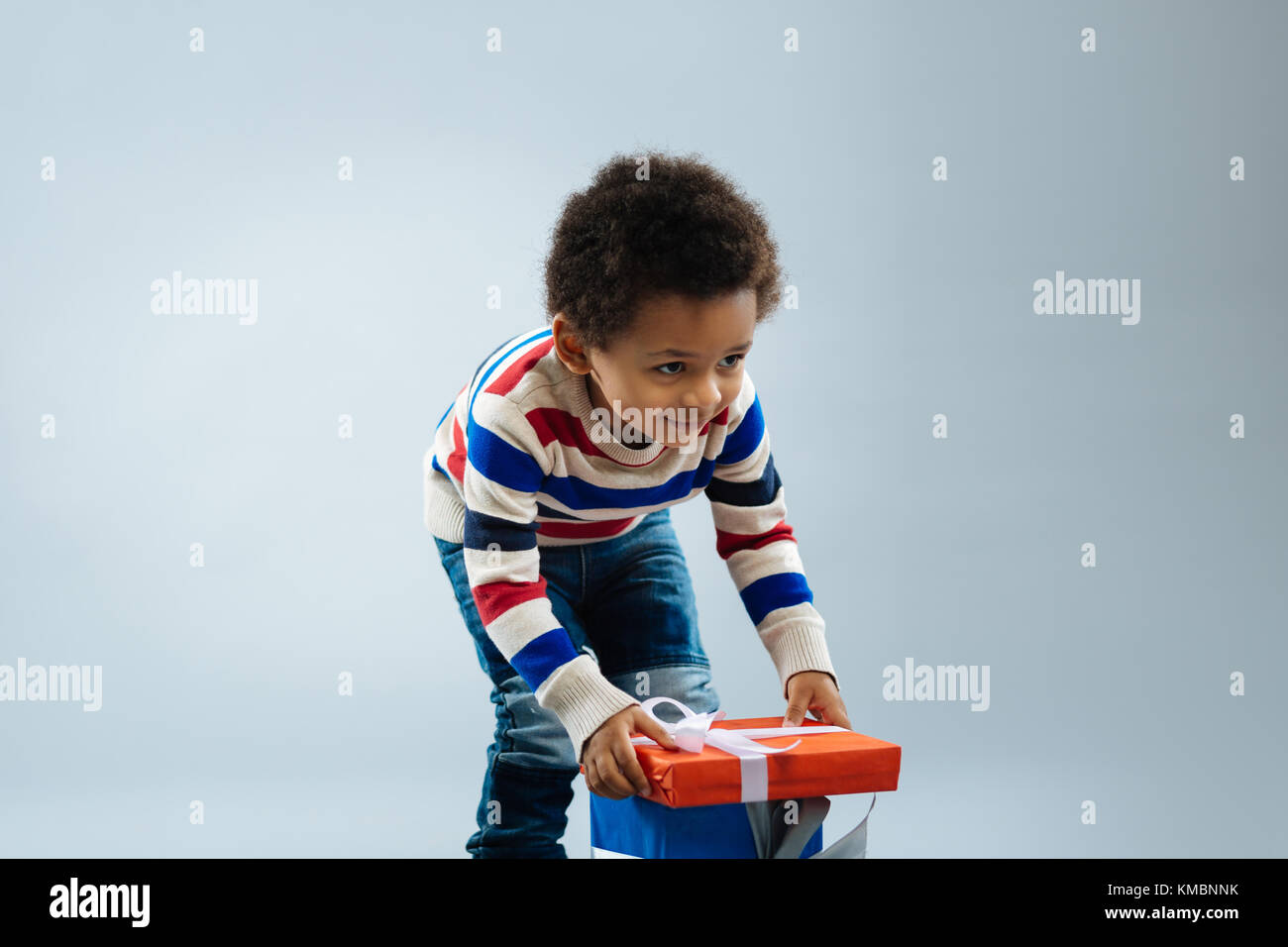 Charming child taking gift box Stock Photo - Alamy