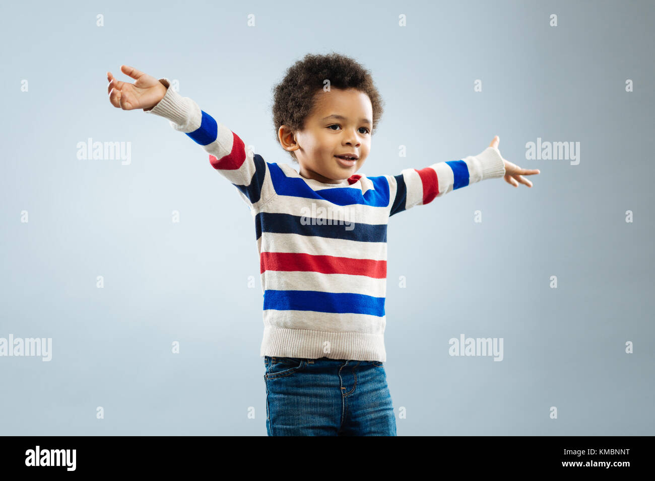 Happy kid raising both arms Stock Photo - Alamy