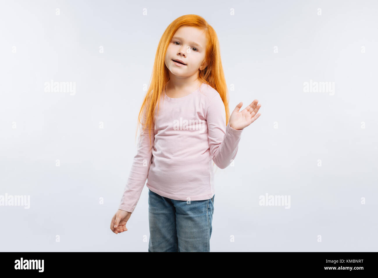 Attentive child waving her left hand Stock Photo - Alamy