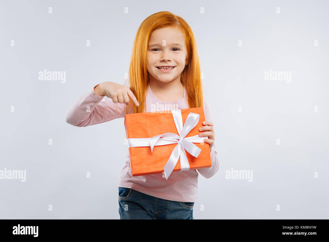 Delighted kid pointing at her present Stock Photo - Alamy