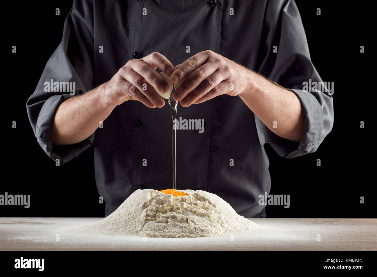 Falling eggs into flour. Hands breaking cracking a raw egg over flour ...