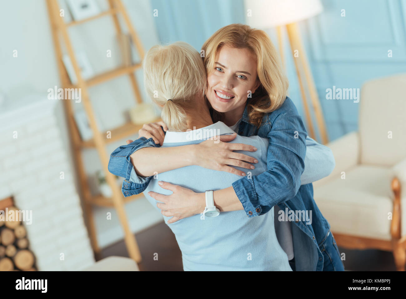 Happy young woman hugging her kind senior relative Stock Photo - Alamy