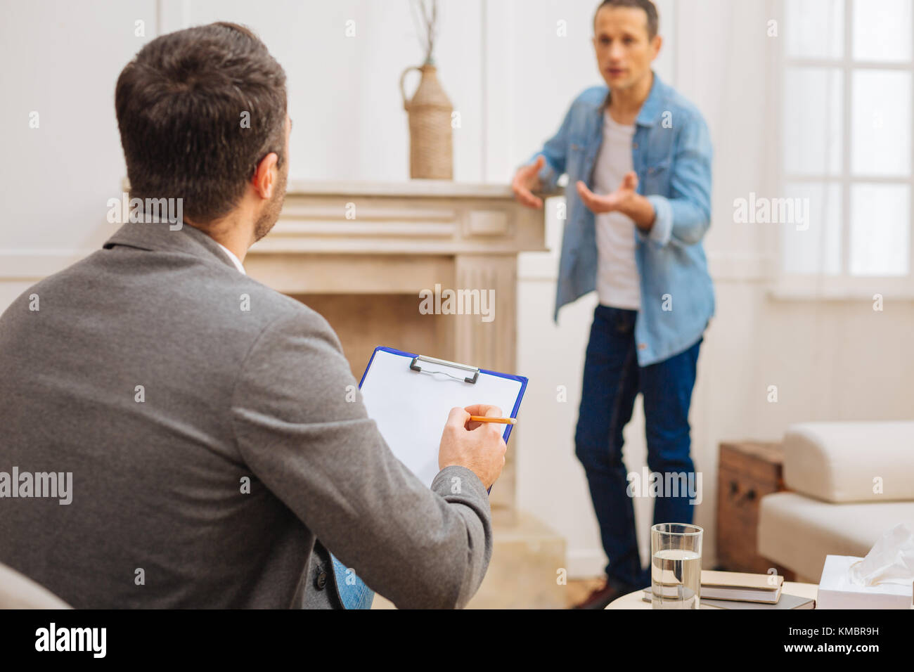 Careful male psychologist conduction session Stock Photo - Alamy