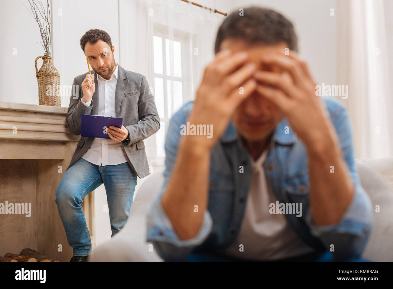 Thoughtful male psychologist observing patient behavior Stock Photo - Alamy