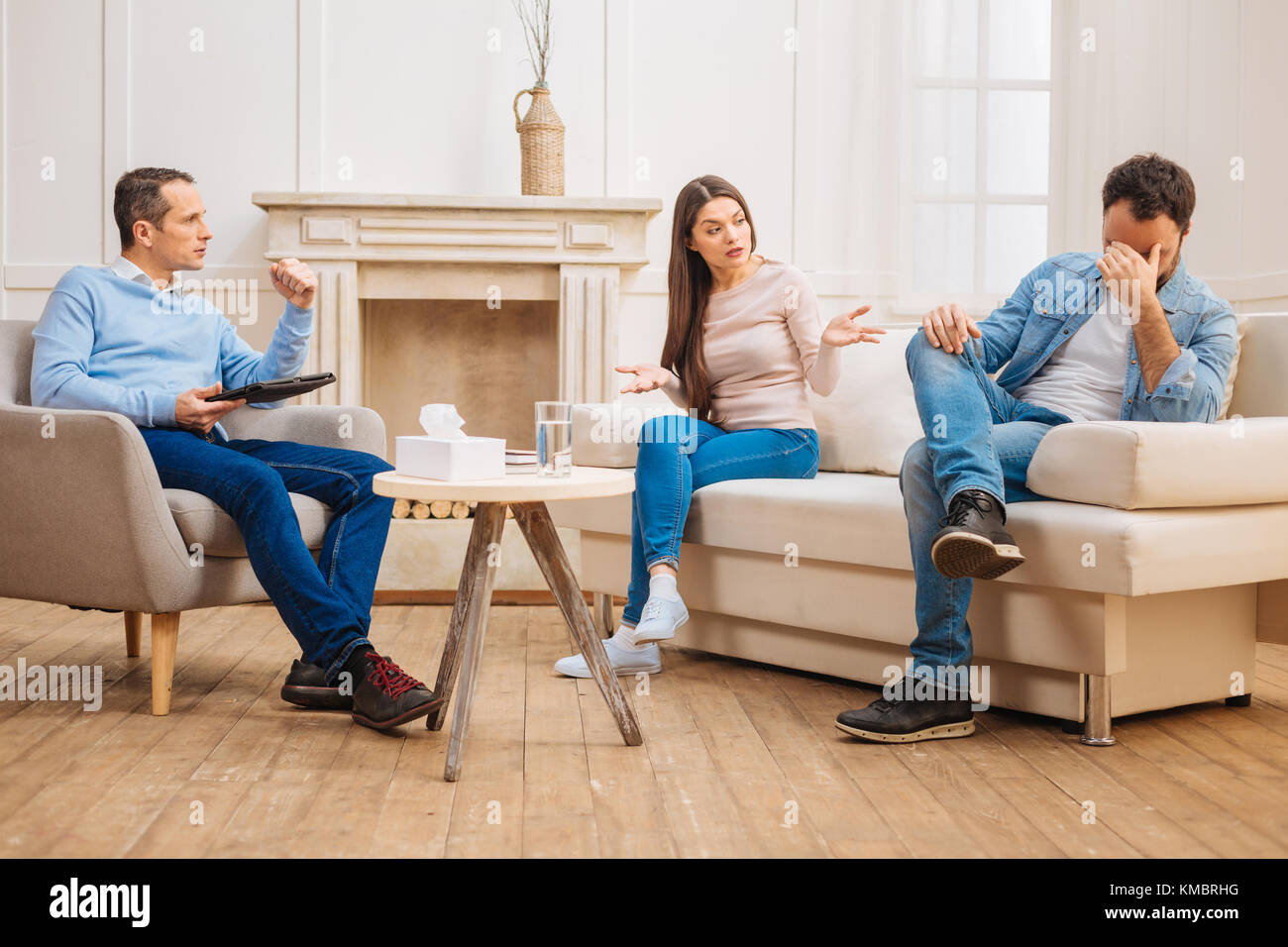 Experienced psychologist observing arguing between young couple Stock ...