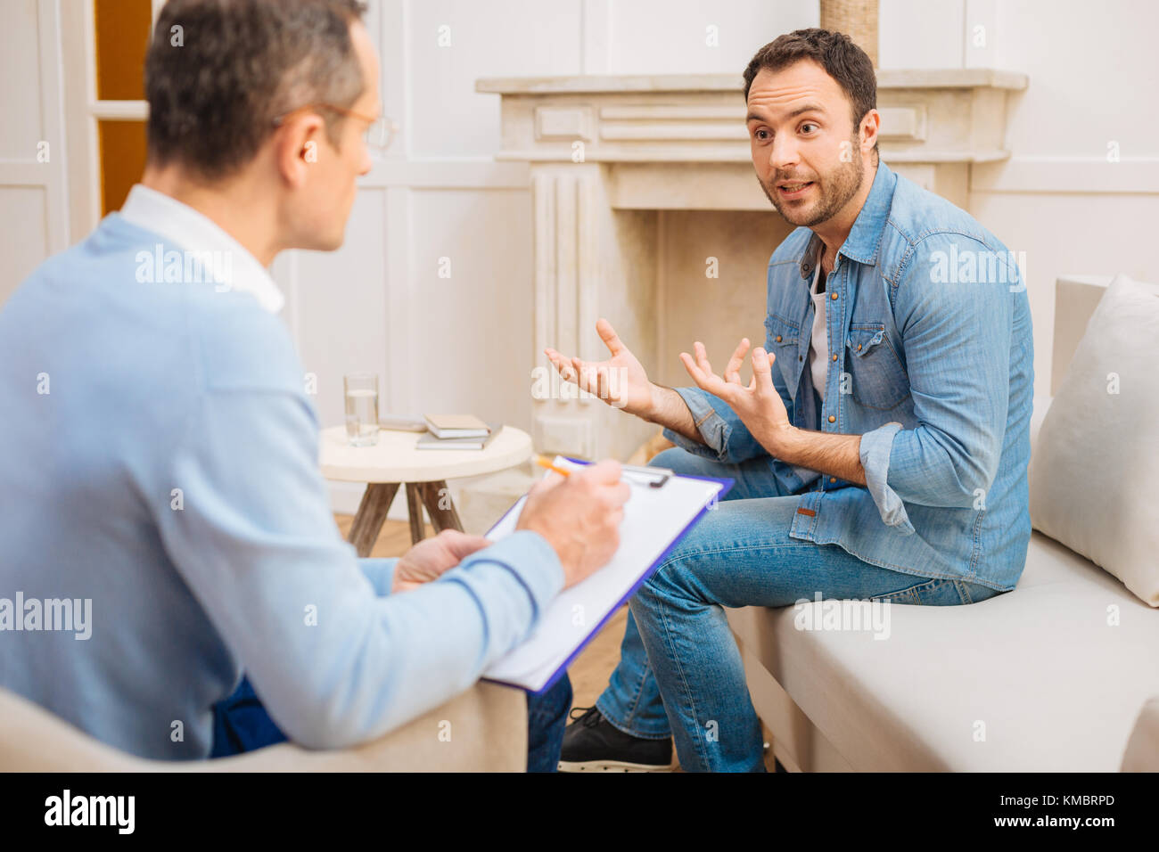 Astonished pretty man explaining his work troubles Stock Photo - Alamy