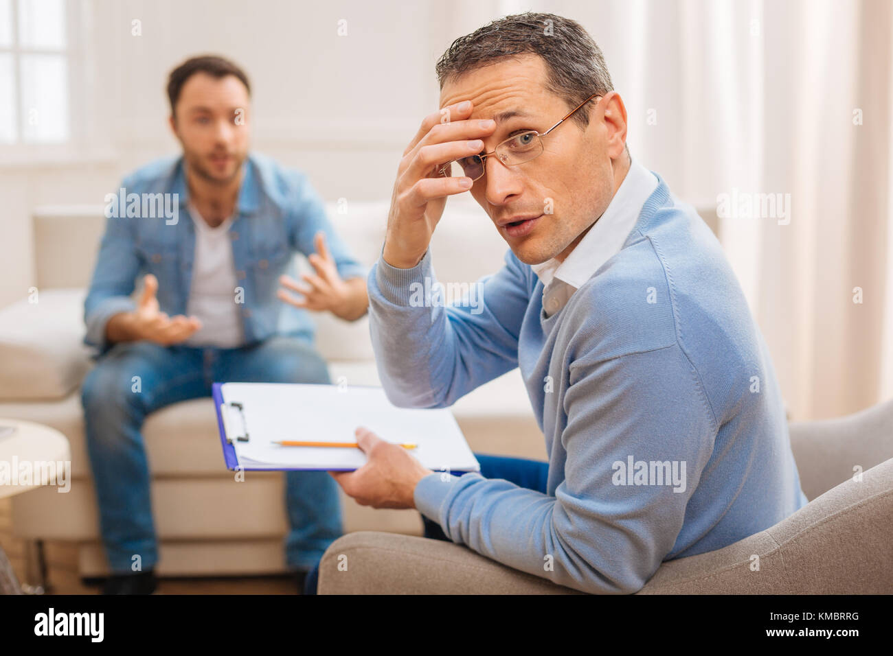 Tired amazed psychologist conducting therapy Stock Photo - Alamy