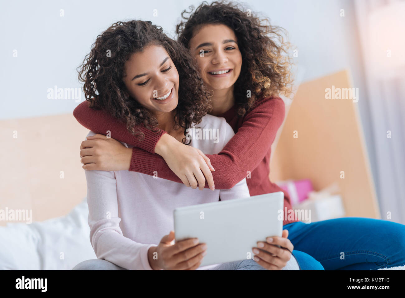 Loving girl embracing her sister tightly Stock Photo - Alamy