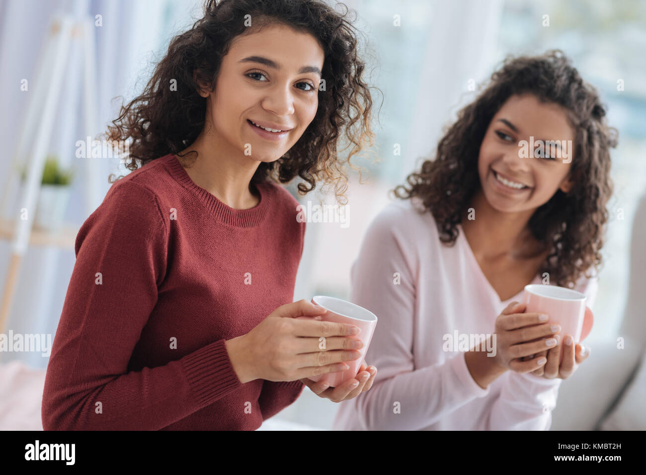 Joyful sisters drinking tea and spending time together Stock Photo - Alamy