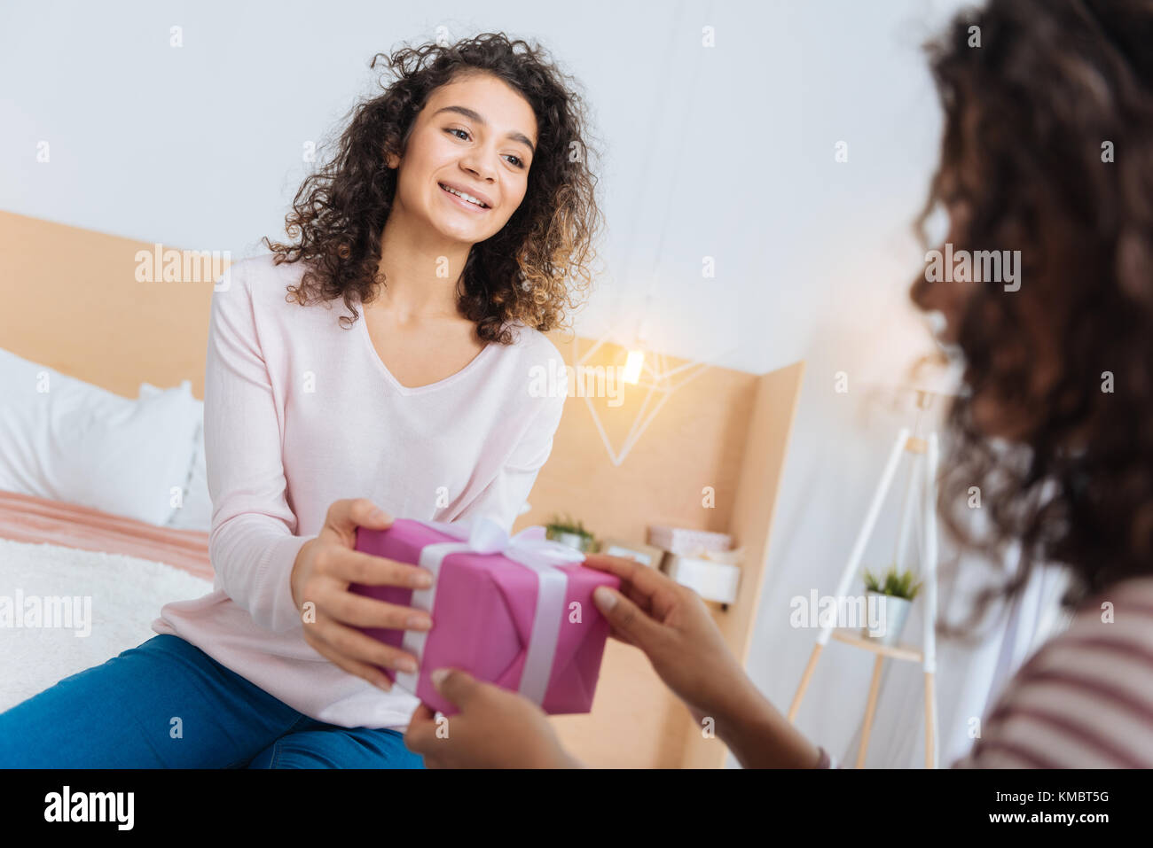 Beautiful girl giving her best friend present Stock Photo - Alamy