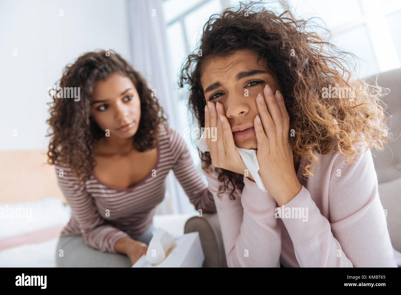 Stressed girl asking her sister for help while crying Stock Photo - Alamy