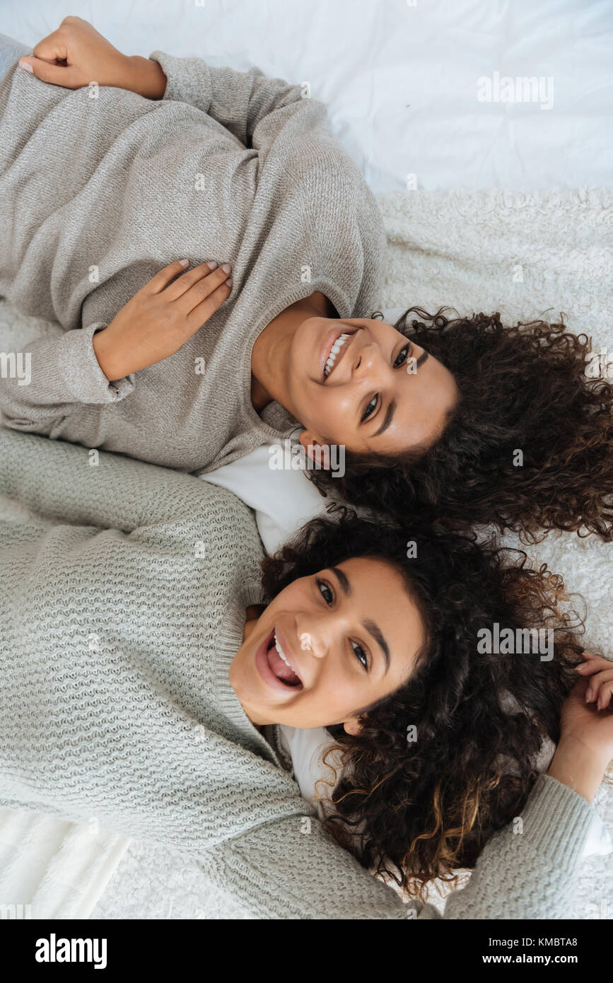 Positive minded siblings beaming while relaxing on bed Stock Photo - Alamy