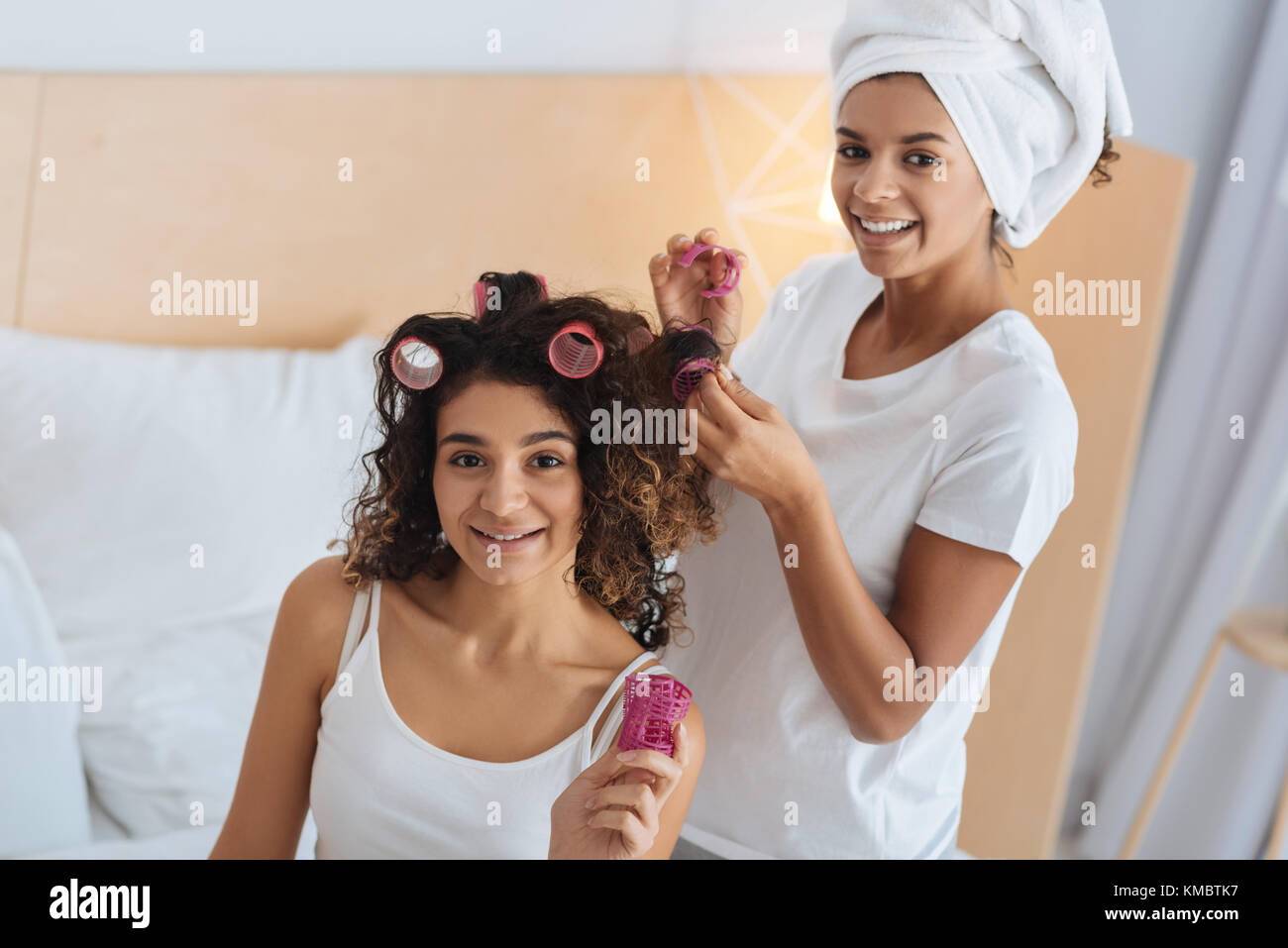 Friendly siblings curling their hair and smiling Stock Photo - Alamy