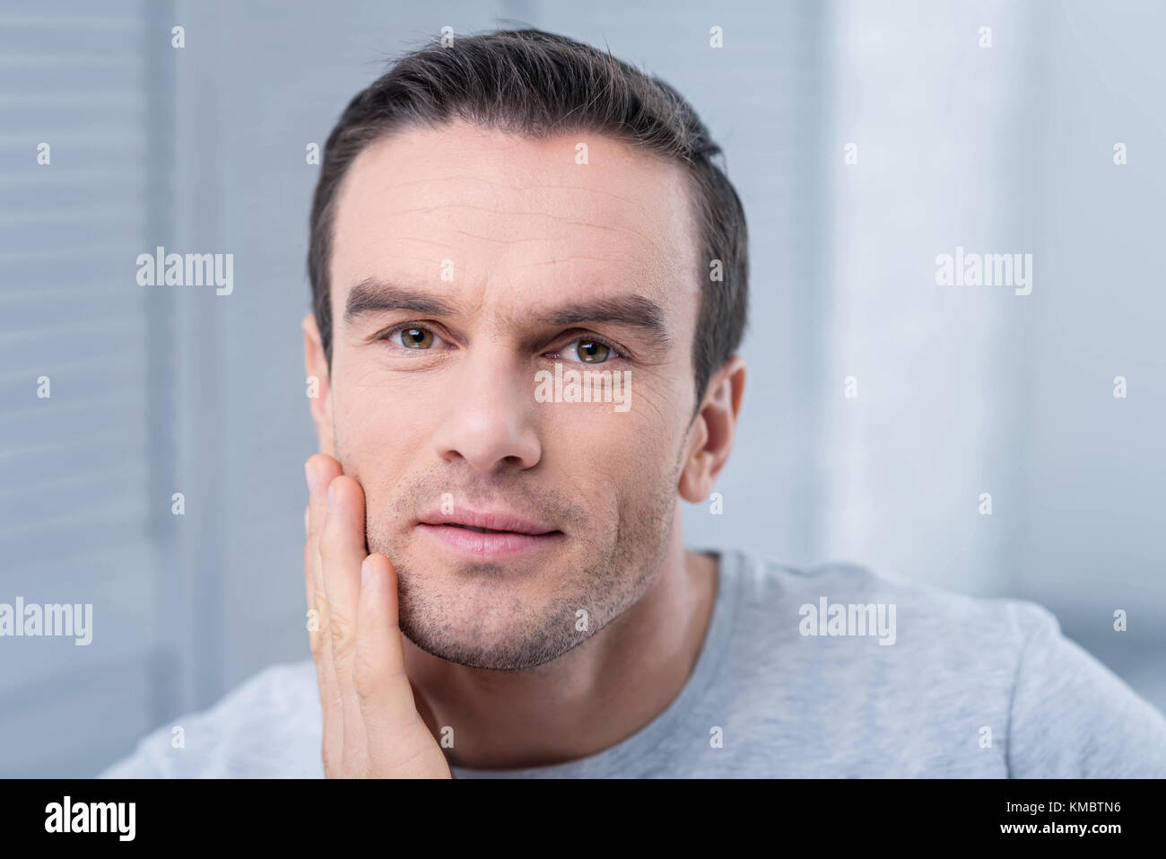 Pensive positive man scrutinizing you Stock Photo - Alamy